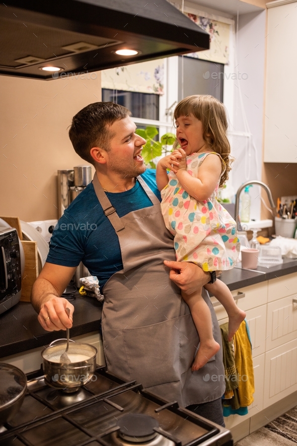 Father and daughter doing household chores in the kitchen. father and ...