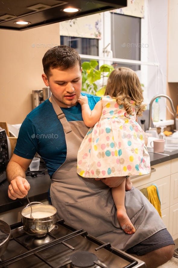 Father and daughter doing household chores in the kitchen. father and ...