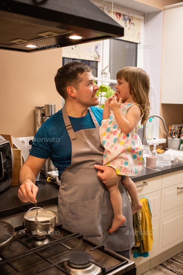 Father and daughter doing household chores in the kitchen. father and ...
