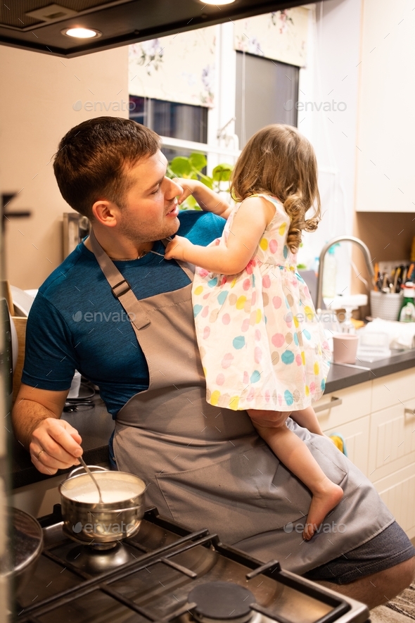 Father and daughter doing household chores in the kitchen. father and ...
