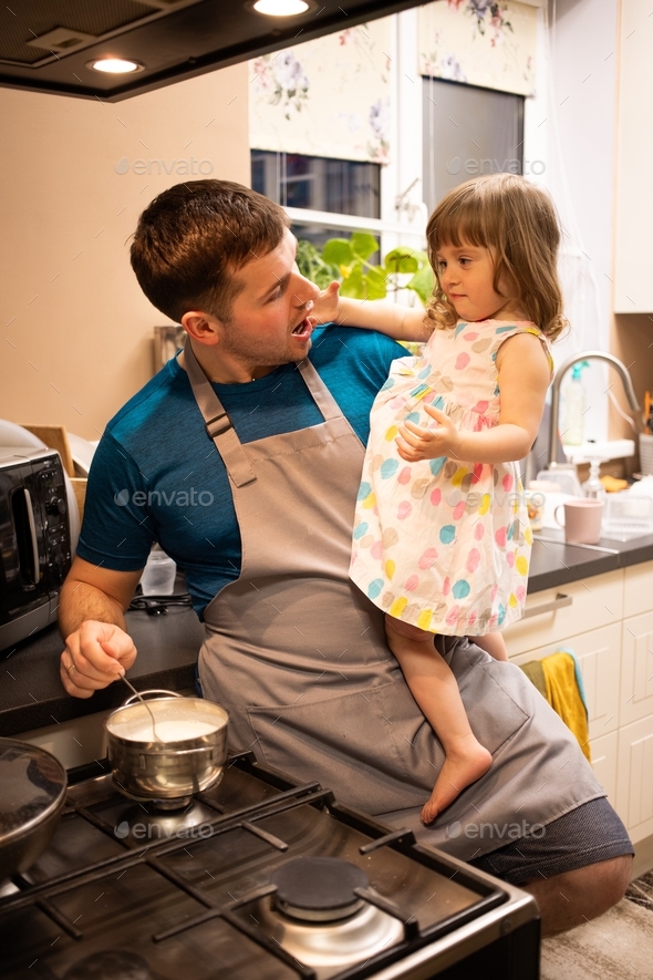 Father and daughter doing household chores in the kitchen. father and ...