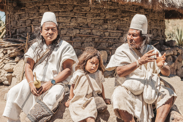 The grandfather, father and son of an indigenous family pose in front ...