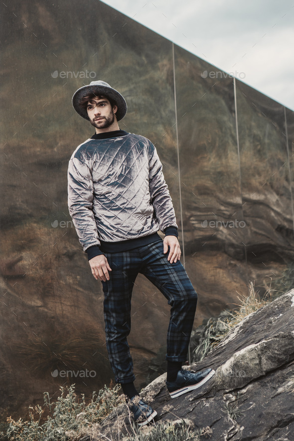 A millennial model poses on a rock in front of a metal structure of ...