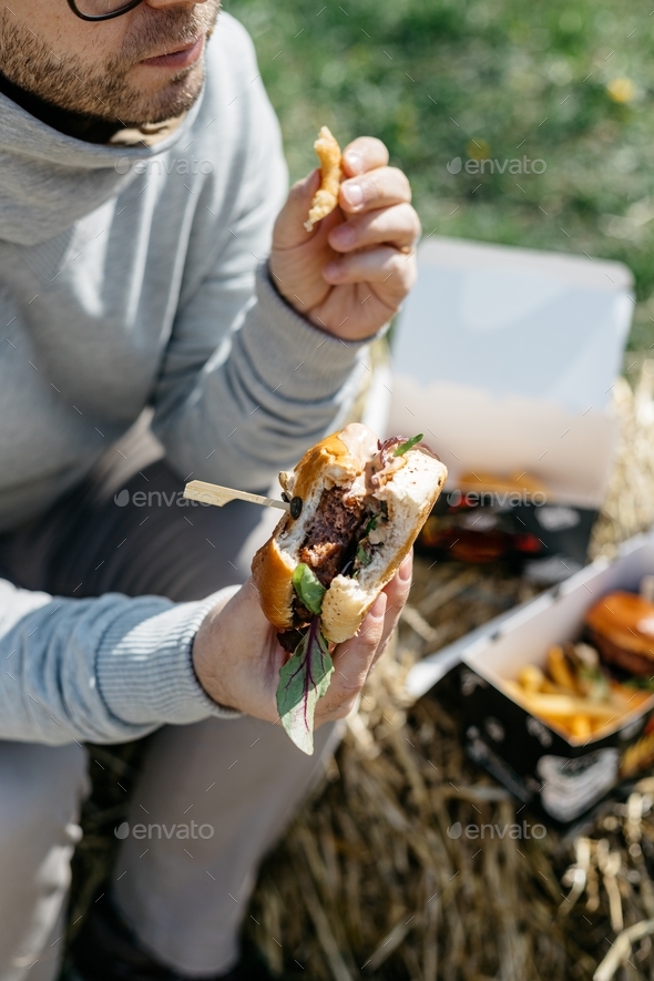 Man eating out at a street food festival, burger amd fries. Stock Photo ...