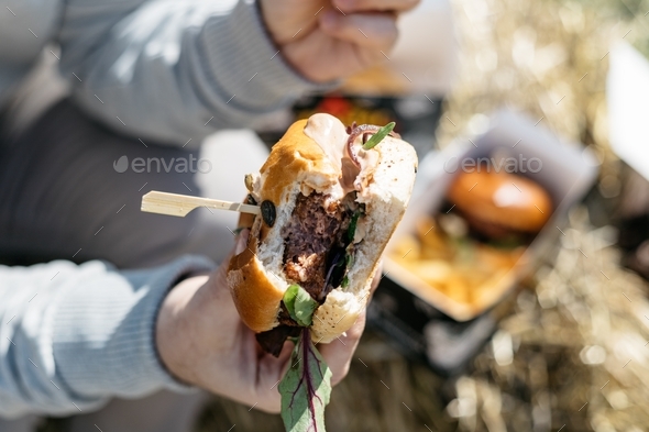 Man eating out at a street food festival, burger amd fries. Stock Photo ...