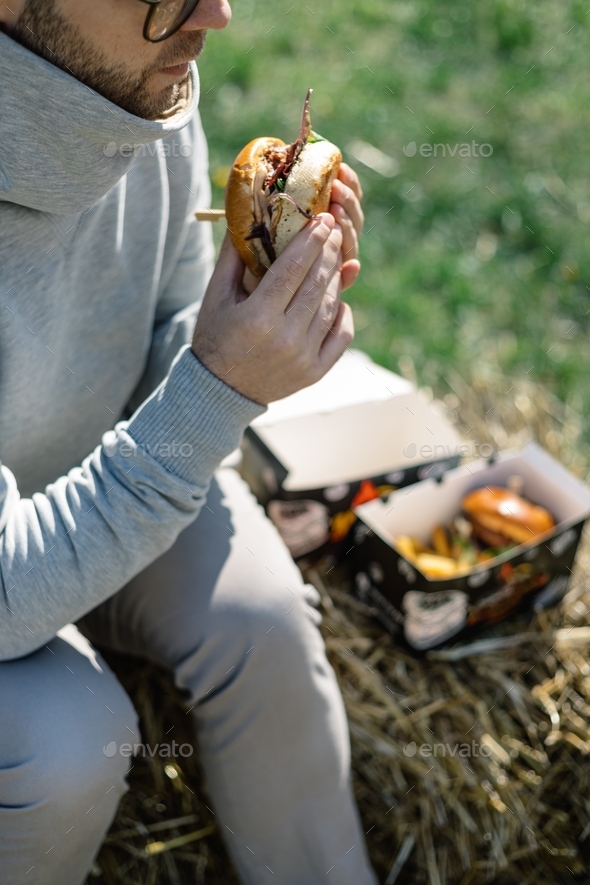 Man eating out at a street food festival, burger amd fries. Stock Photo ...