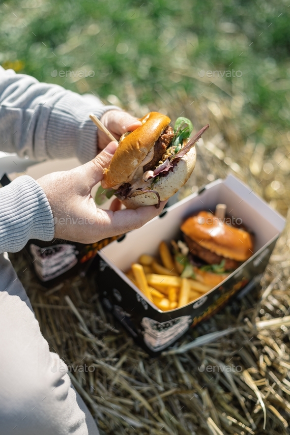 Man eating out at a street food festival, burger amd fries. Stock Photo ...