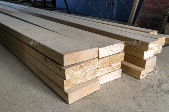 Stack of new wooden studs at the lumber yard. Wood timber construction ...