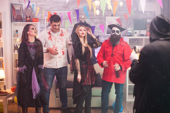 Back view of grim reaper taking photos of vampire Stock Photo by DC_Studio