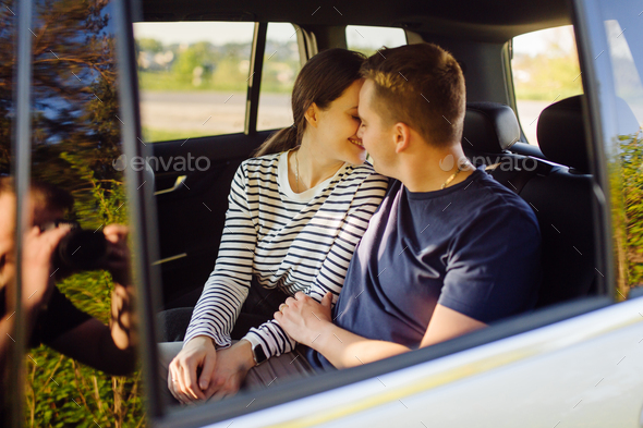 Smiling young couple inside a car. Kissing in the car Stock Photo by ...