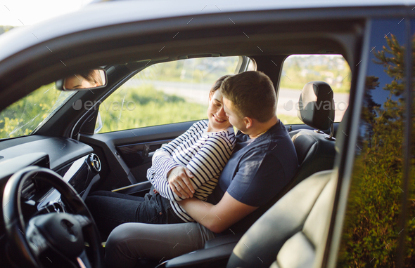 Smiling young couple inside a car. Kissing in the car Stock Photo by ...