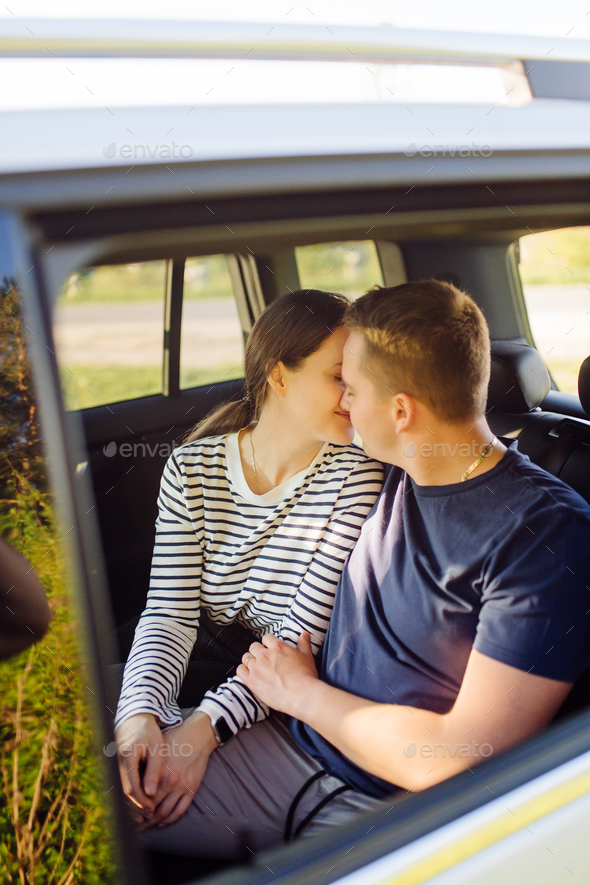 Smiling young couple inside a car. Kissing in the car Stock Photo by ...