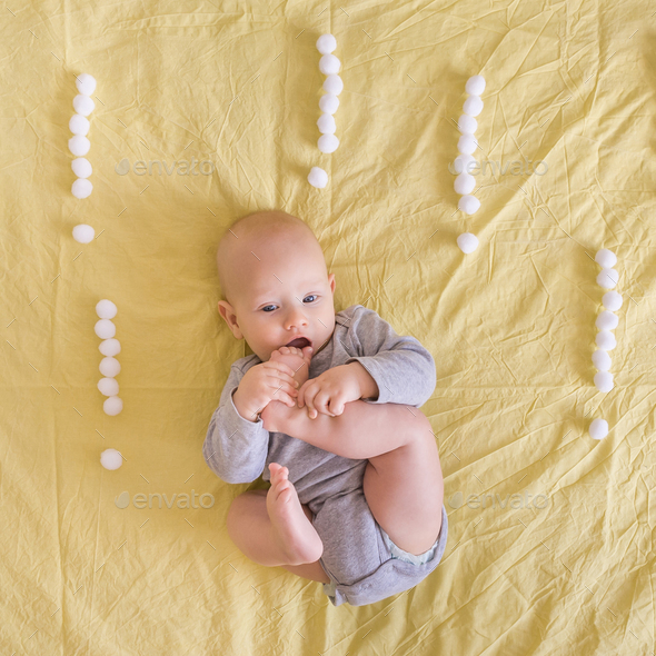 top view of cute infant child lying surrounded with exclamation marks ...