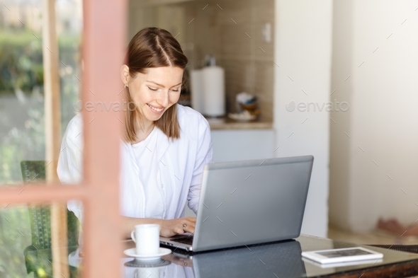 Attractive young woman working on a desktop computer smiling as she ...