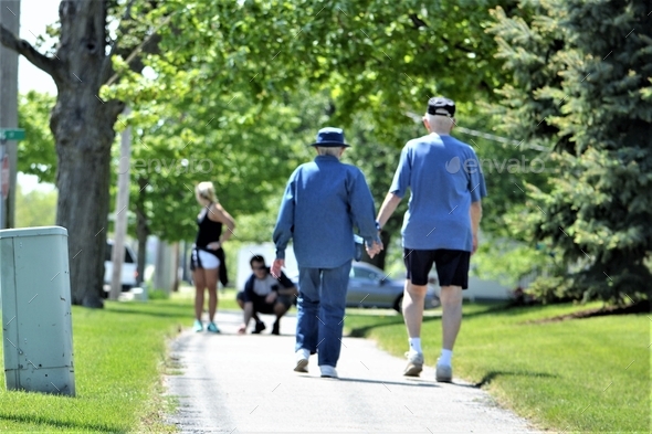 Active senior citizens holding hands and walking for exercise Stock ...