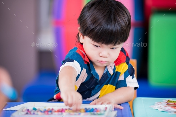Adorable Asian boy reached for pick up chalk paint, baby made art on ...