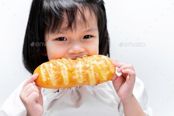 Child are happy to eat soft sweet bread. Children's snacks. Girl ...