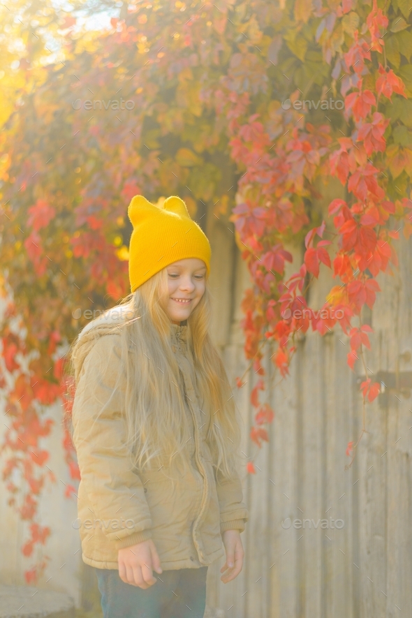 vertical portrait of a little girl smiling shyly on a background of red ...