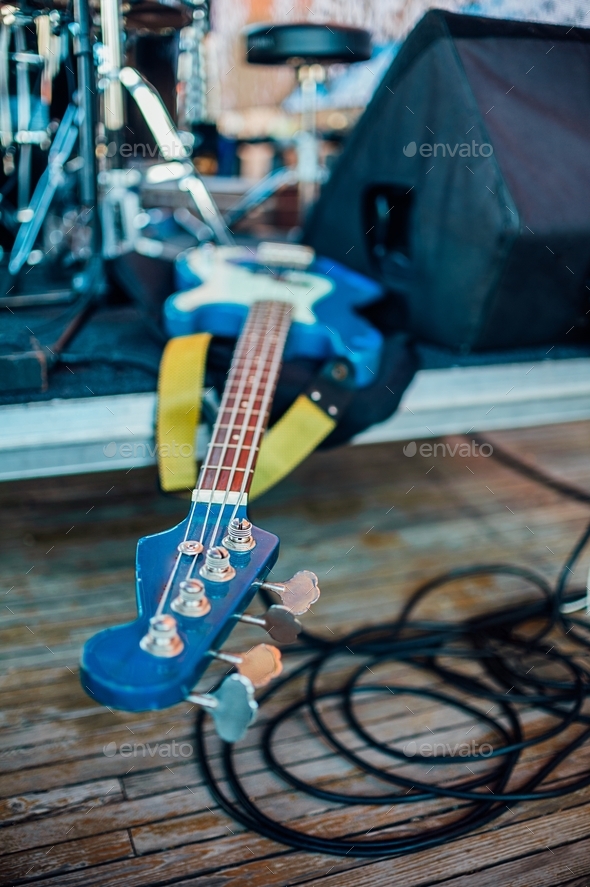 professional guitar lies on stage among wires and musical instruments ...