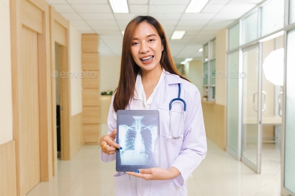 portrait of smart female doctor holding tablet to show X-Ray picture ...