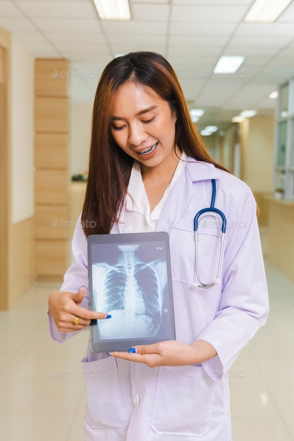 portrait of smart female doctor holding tablet to show X-Ray picture ...