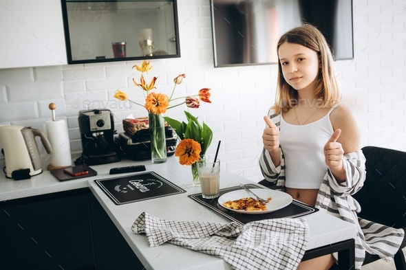 11 year old girl having breakfast at home in the kitchen Stock Photo by ...