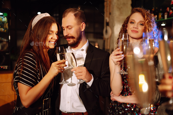 Cheering, drinking cocktails. Group of friends partying in nightclub ...