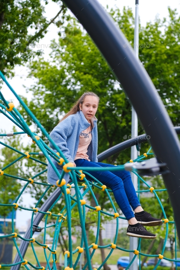 A middle school age teenager girl in a rope park. Joy and fun. Hobby ...