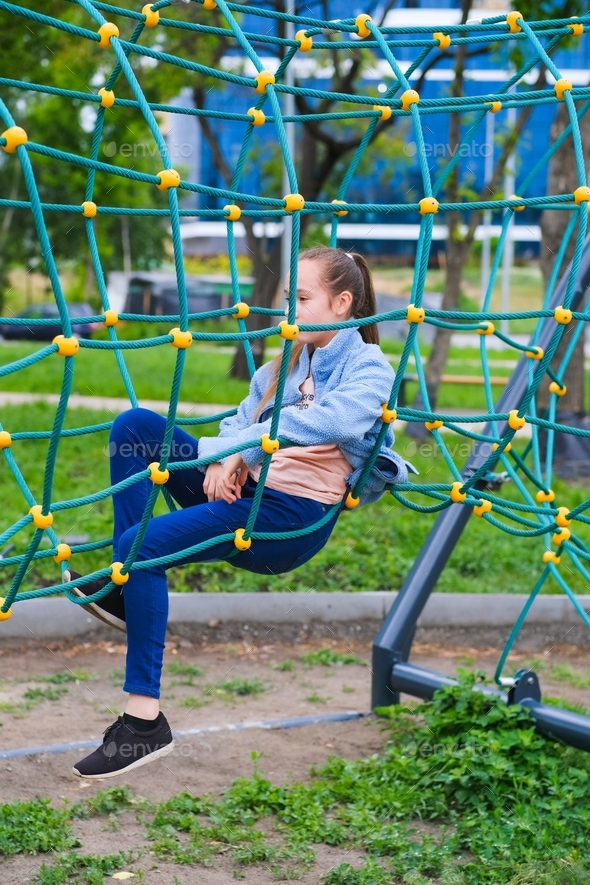 A middle school age teenager girl in a rope park. Joy and fun. Hobby ...