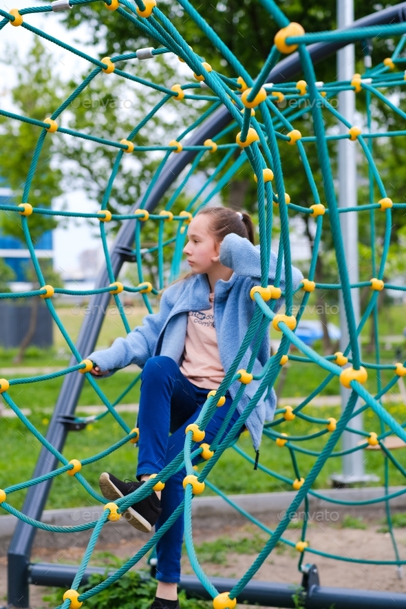A middle school age teenager girl in a rope park. Joy and fun. Hobby ...