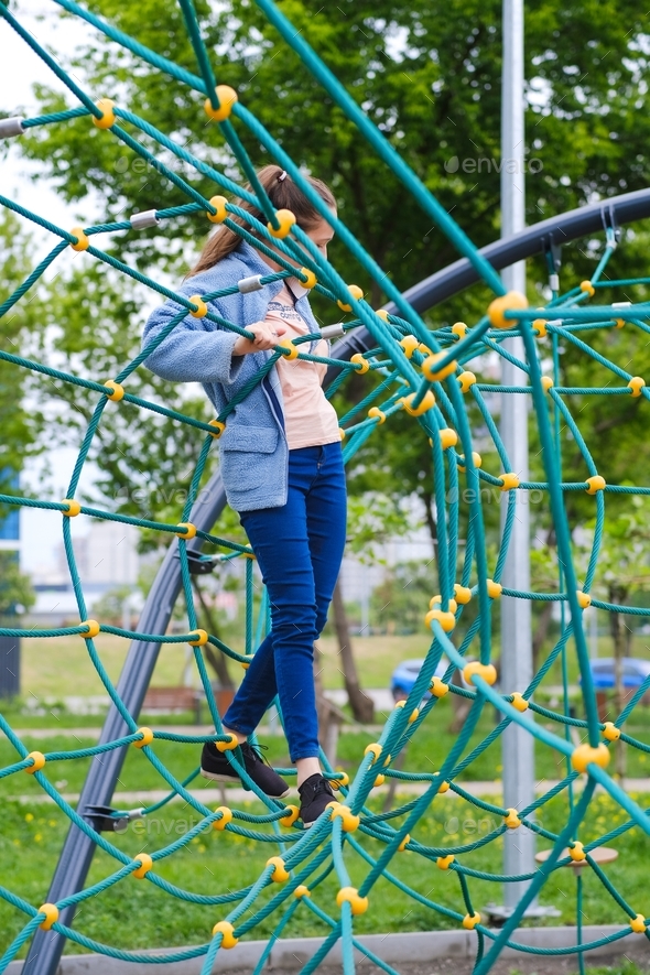 A middle school age teenager girl in a rope park. Joy and fun. Hobby ...