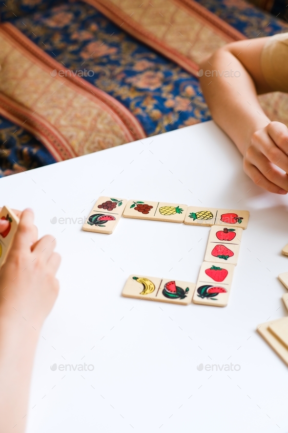 Two children are playing board games. Tic-tac-toe and dominoes. Cozy ...