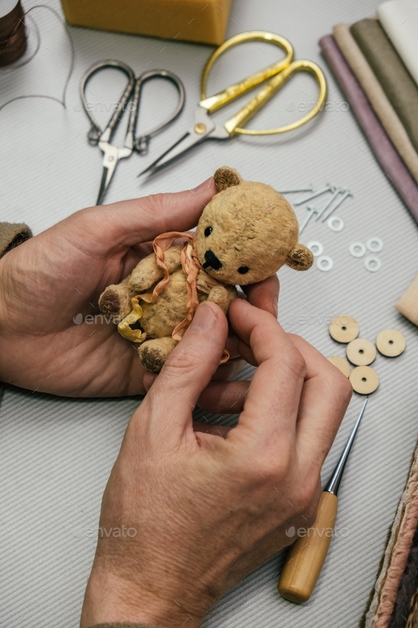 Teddy master man holds hand-sewn teddy bear in his hands. Small ...
