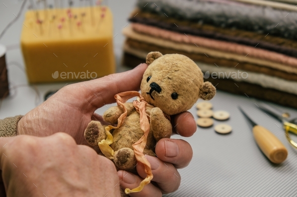 Teddy master man holds hand-sewn teddy bear in his hands. Small ...