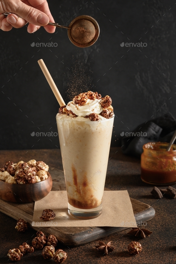 Tasty banana and caramel milkshake garnished whipped cream and popcorn ...
