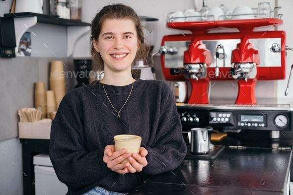 Smiling and positive generation Z girl working in a cafe and making ...