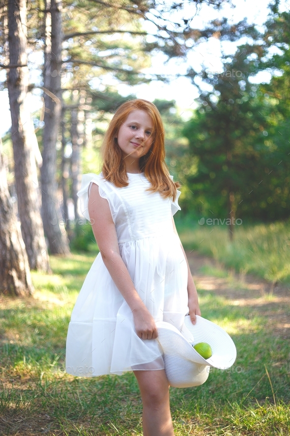 red-haired teen girl in a white dress for a walk in the park Stock ...