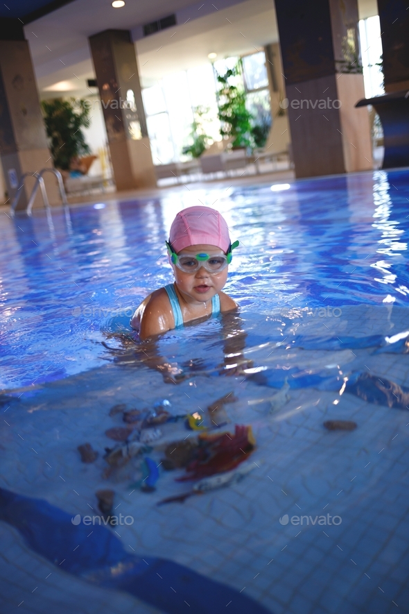 little girl doing exercises in the pool Stock Photo by Aleksandra_Iarosh