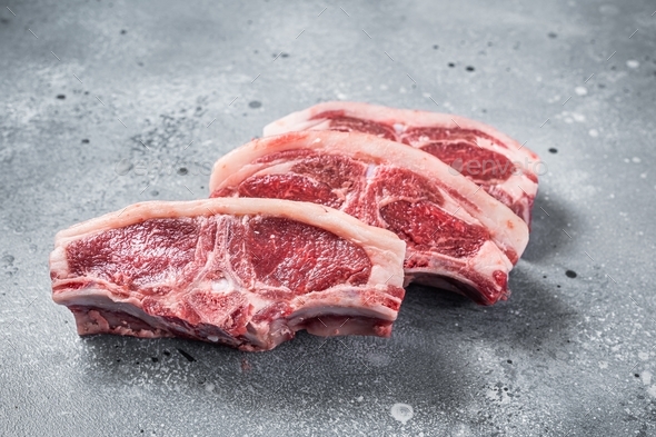 Raw fresh meat lamb mutton saddle. Gray background. Top view. Copy ...
