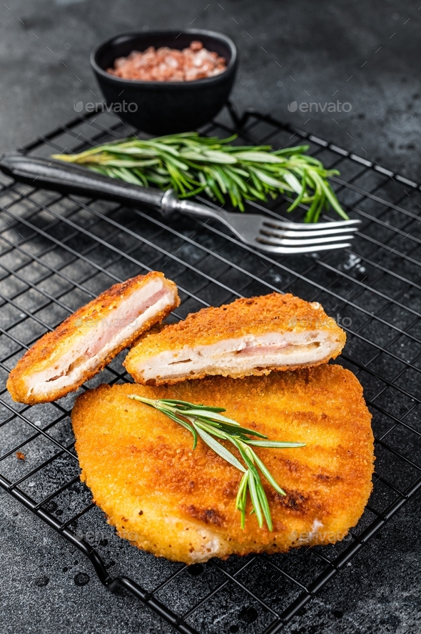 Schnitzel Cordon bleu fillet cutlet with ham and cheese. Black ...
