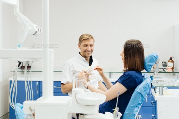 Dentist doctor guiding the woman patient how correctly to clean the ...