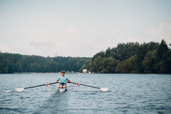Sportsman single scull man rower rowing at competition boat regatta ...