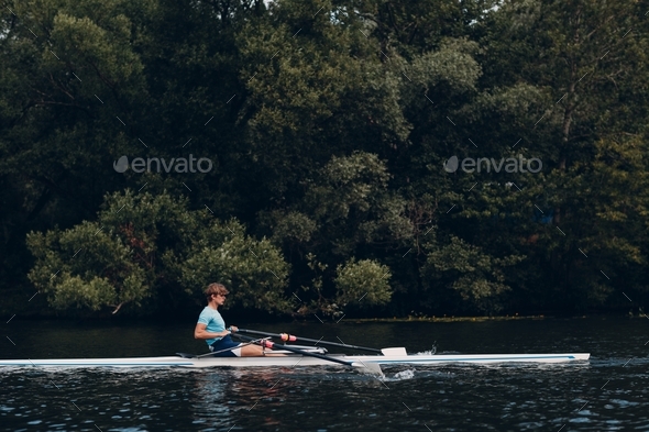 Sportsman single scull man rower rowing at competition boat regatta ...