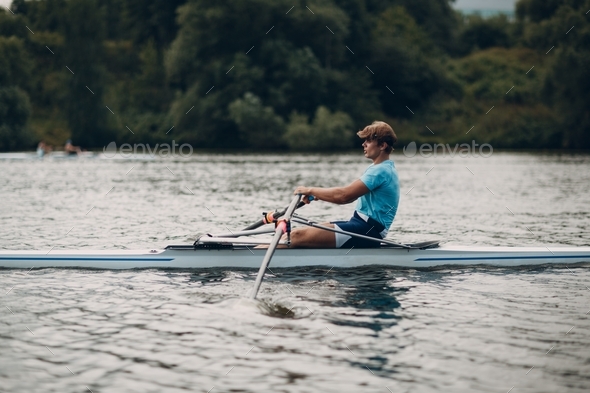 Sportsman single scull man rower rowing at competition boat regatta ...