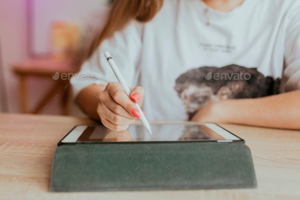 young woman solves geometry examples on a tablet Stock Photo by shulenyka