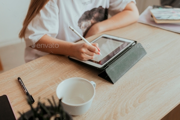 young woman solves geometry examples on a tablet Stock Photo by shulenyka