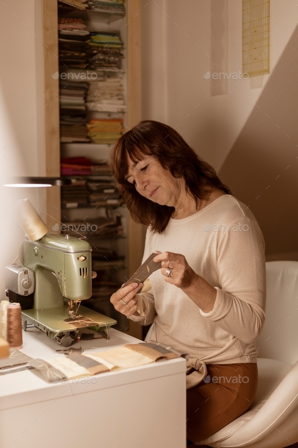 Caucasian brunette woman sewing fabric with a vintage, retro sewing ...