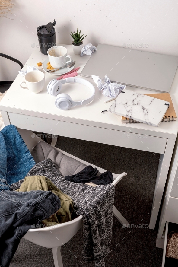 Messy table with laptop, dirty cups, and stationary items. Cluttered ...