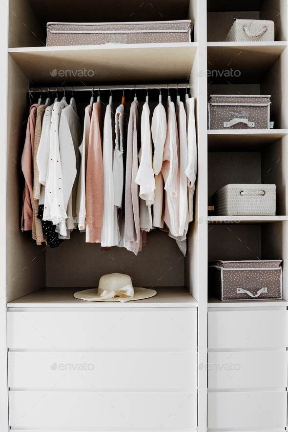 Closet with clothes hanging, organizing and ordering in wardrobe with ...