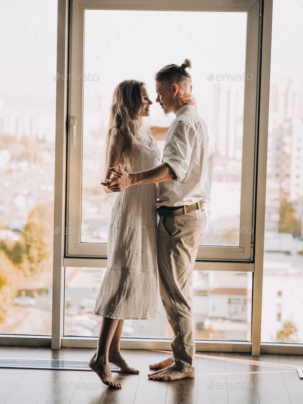 Beautiful young man-woman couple dance and hug near window Stock Photo ...